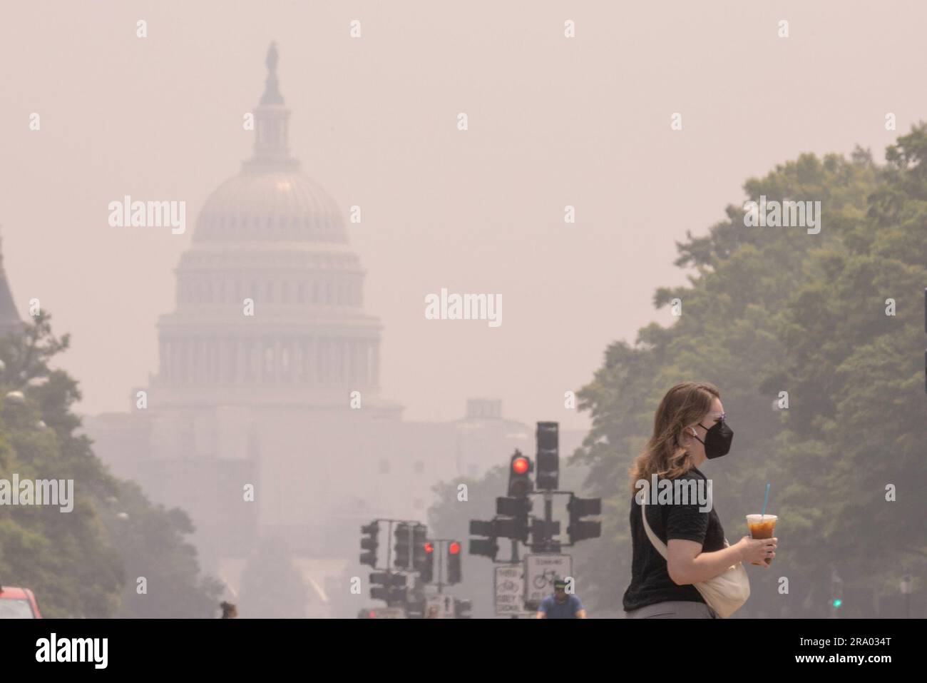 Washington, USA. 29th June, 2023. A pedestrian wearing a face mask is ...
