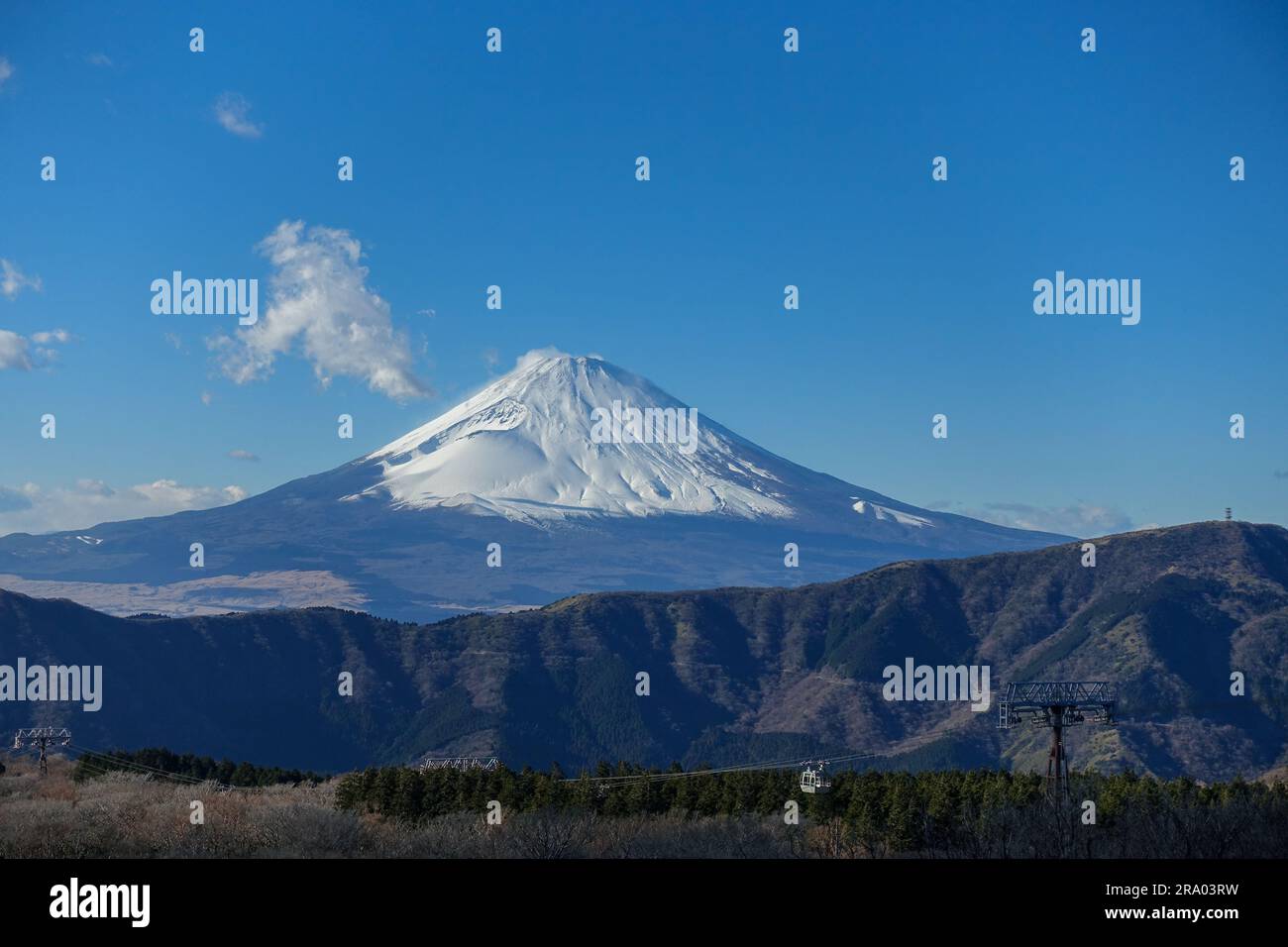 Snow-capped cone-shaped Mount Fuji and the Owakudani cablecar seen from ...
