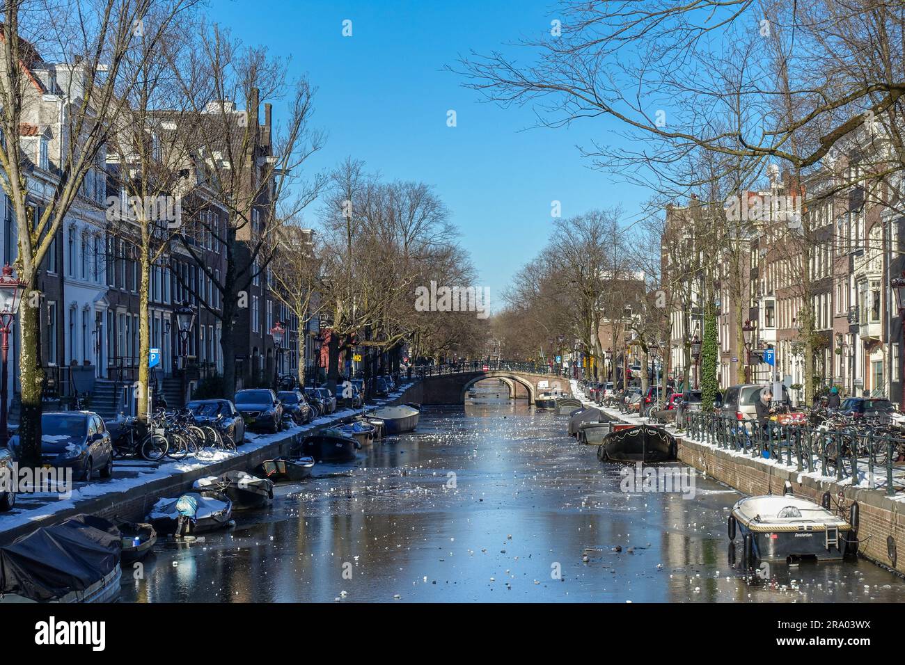 Boats on the frozen canals of Amsterdam during a cold winter day of ...
