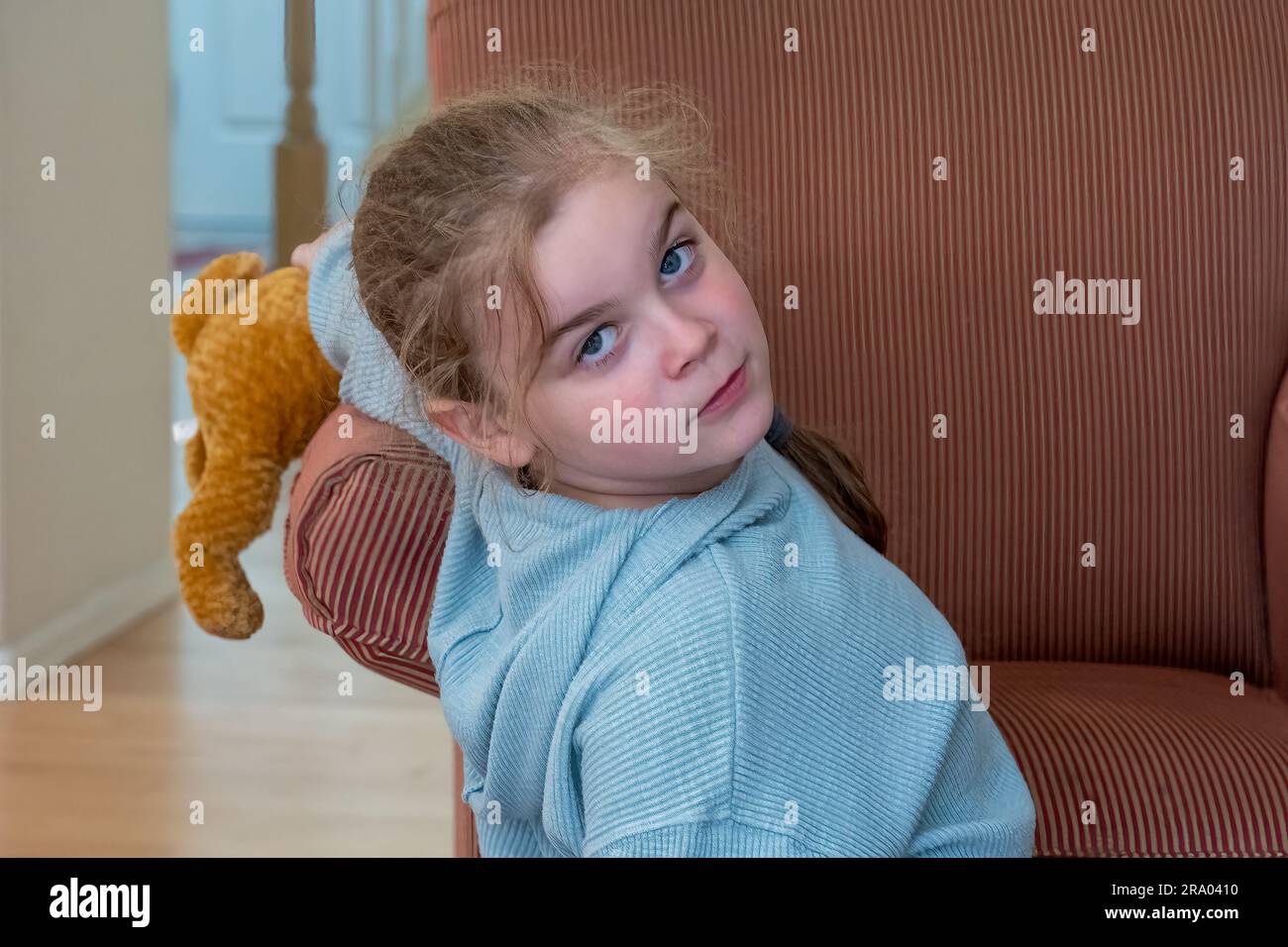 Portrait of a 7 year old girl looking back over her shoulder, as she ...
