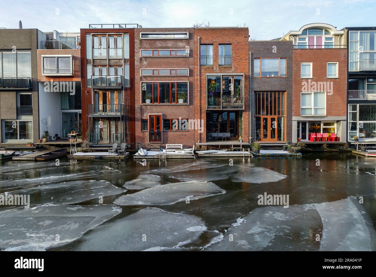 Frozen canals and ice blocks in front of the historical architecture of ...