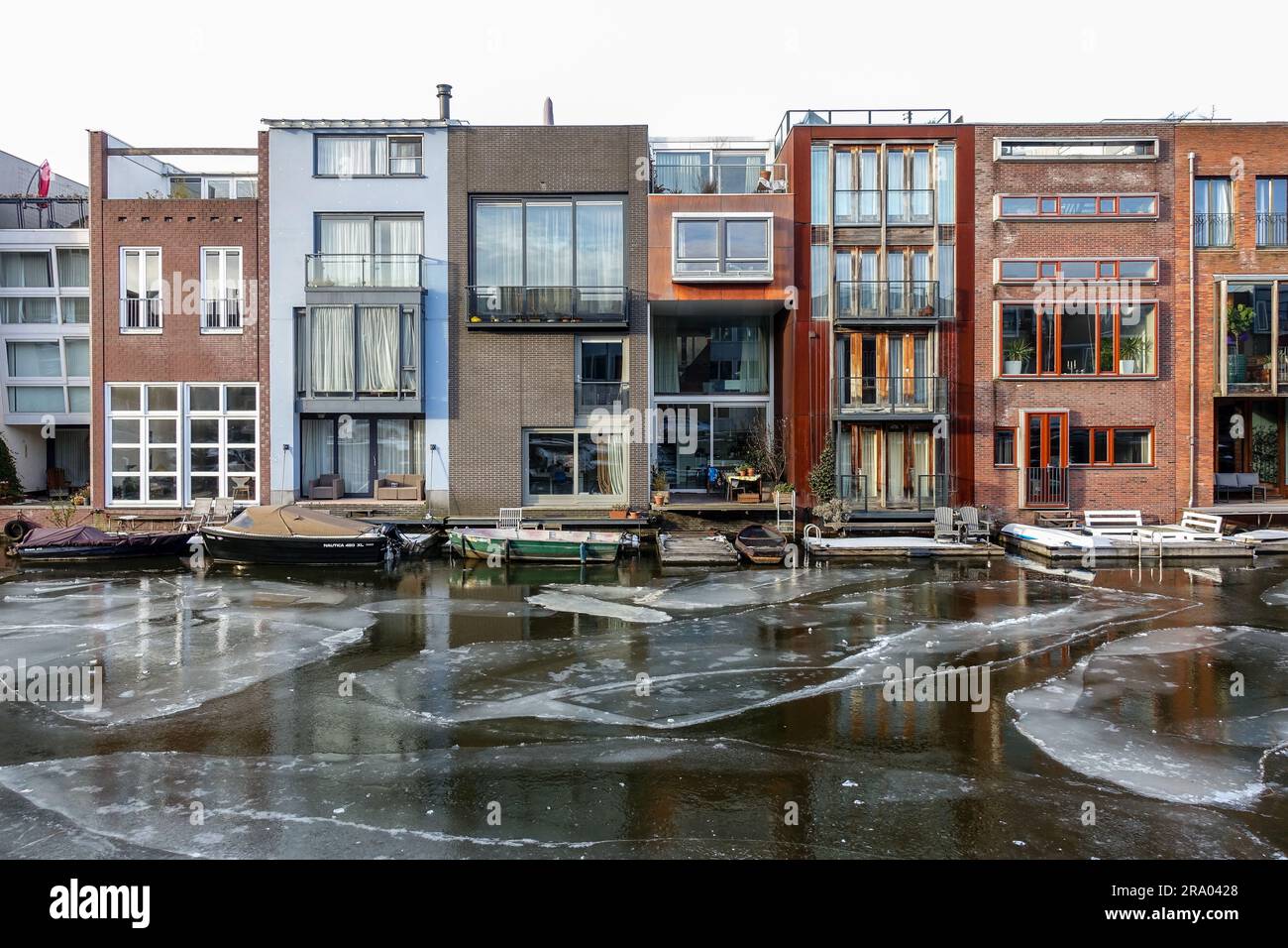 Frozen canals and ice blocks in front of the historical architecture of ...