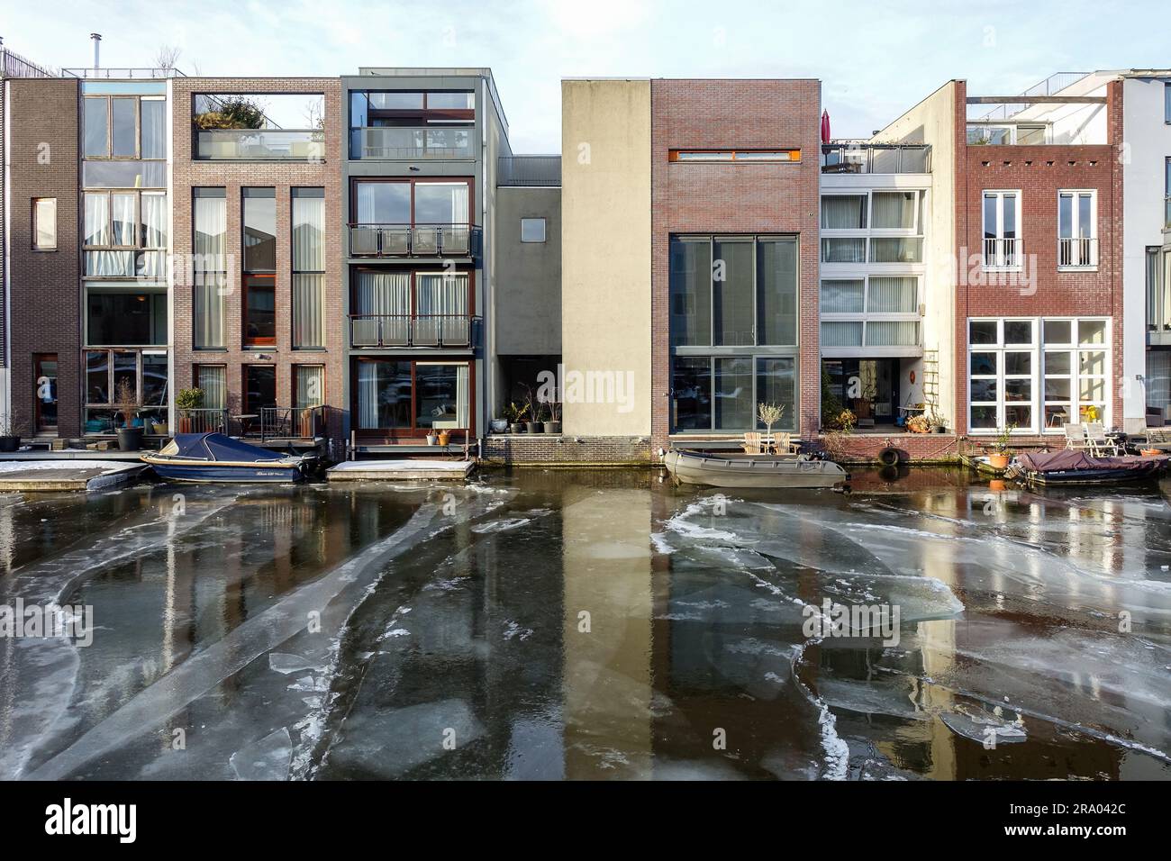Frozen canals and ice blocks in front of the historical architecture of ...