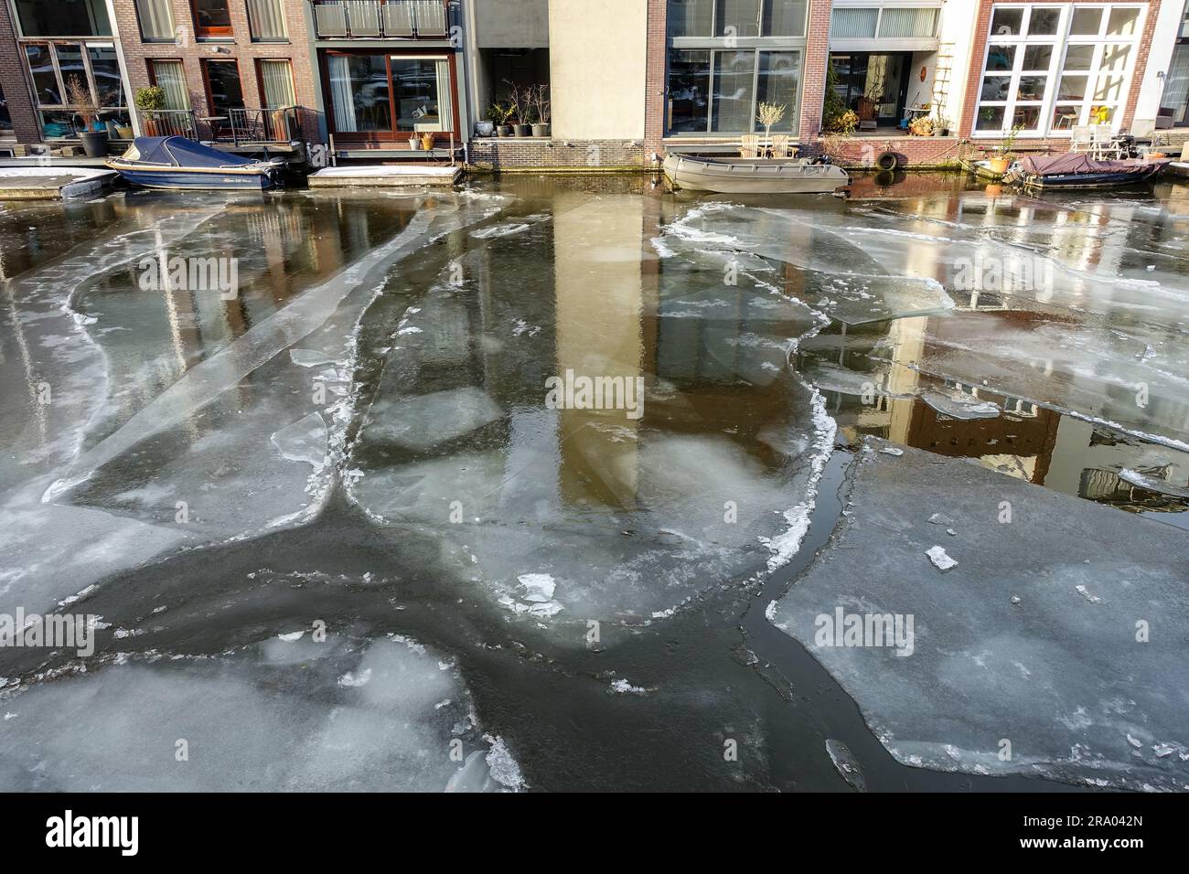 Frozen canals and ice blocks in front of the historical architecture of ...