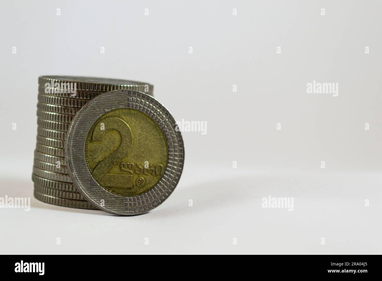 A stack of Georgian Lari coins with a 2 Lari coin leaning on it on a ...