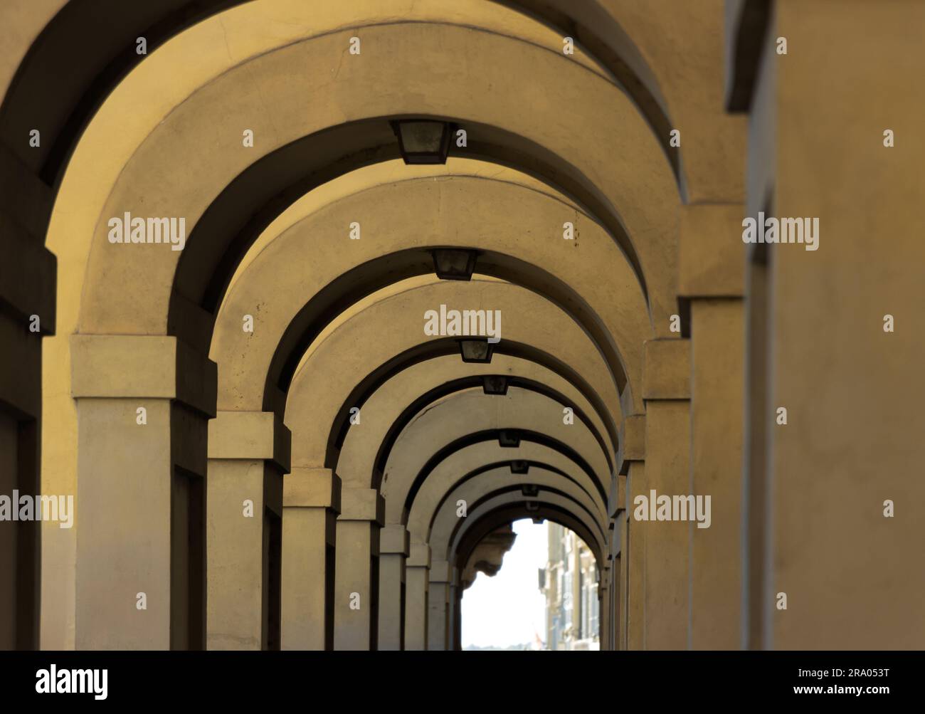 Corridor with rows of columns and arc in sunlight, Detail of the ...