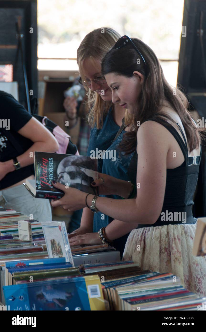 Two young women browsing books at a street stall in central London Stock Photo - Alamy
