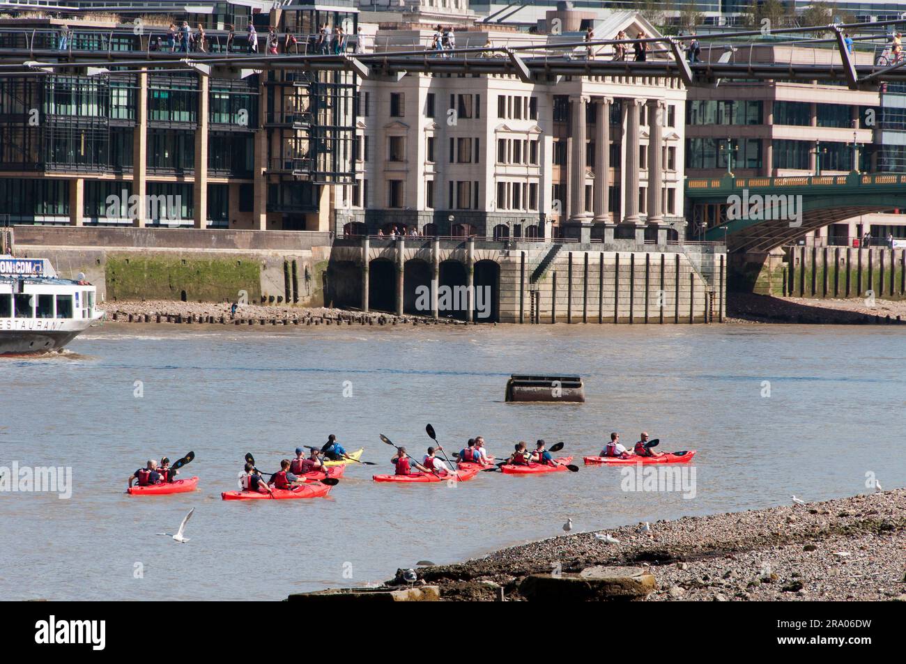 A group of kayakers pass underneath The Millennium Bridge in London ...