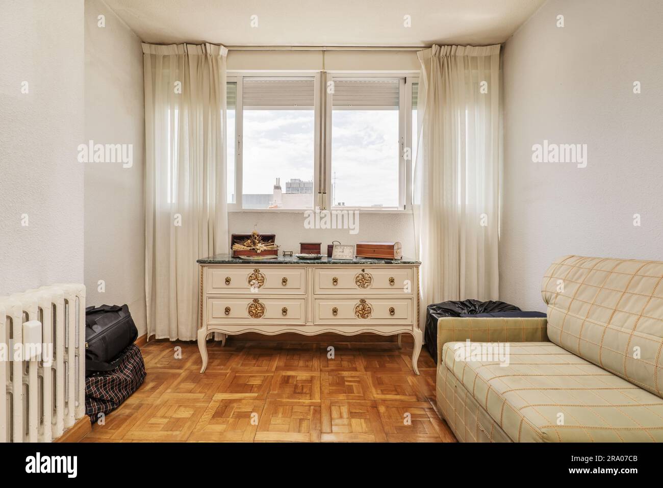 Room with a white classic wooden sideboard under the window and a light ...