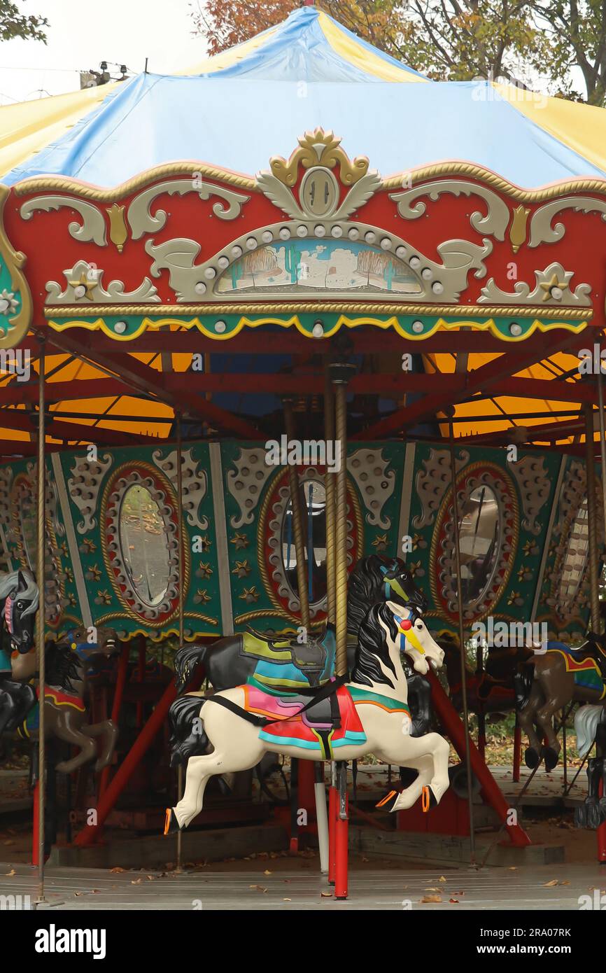 vertical of colorful carousel featuring horse in running stance waiting ...