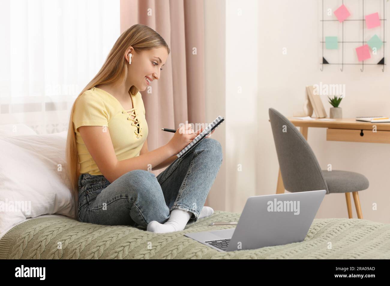 Teenage girl writing in notebook on bed at home Stock Photo - Alamy
