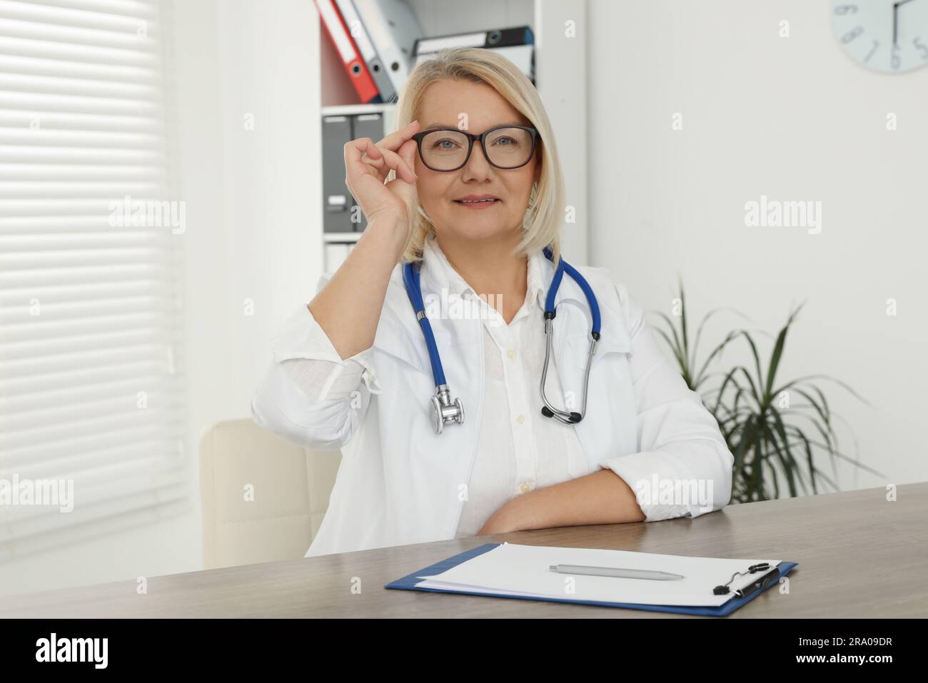 Female physician sitting wooden table hi-res stock photography and ...