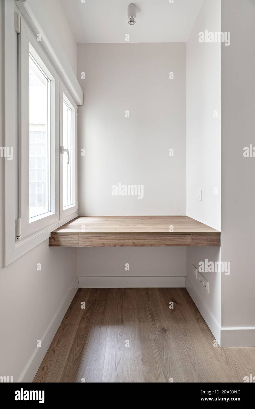 Custom wooden study table with integrated drawer next to a white ...