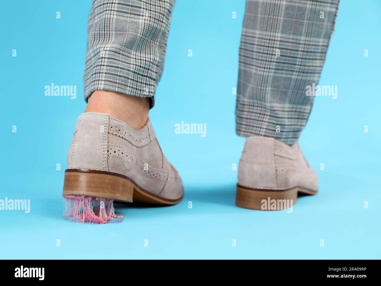 Person stepping into chewing gum on light blue background, closeup ...