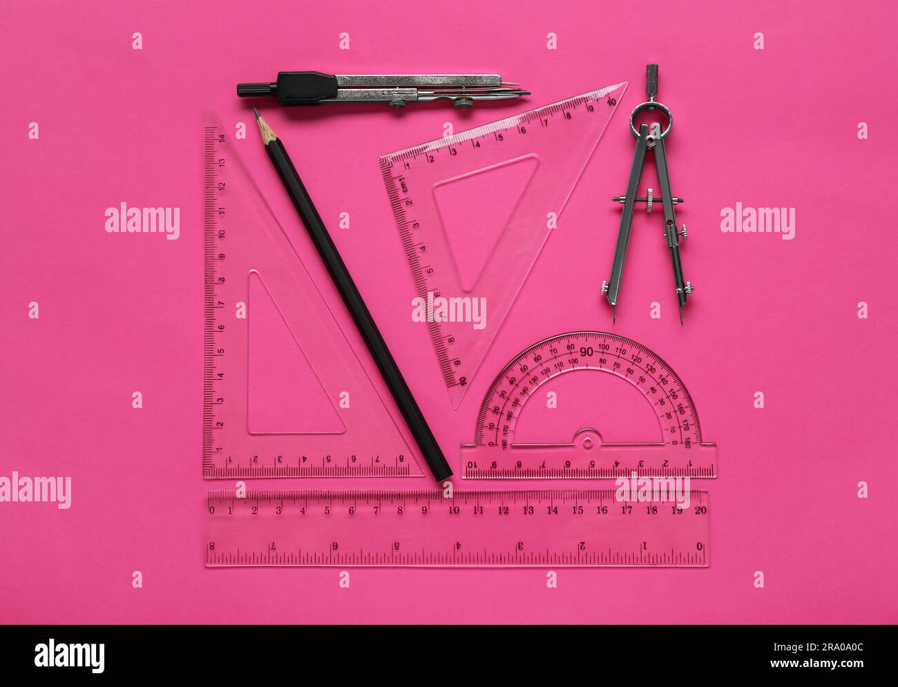 Flat lay composition with different rulers and compass on pink ...