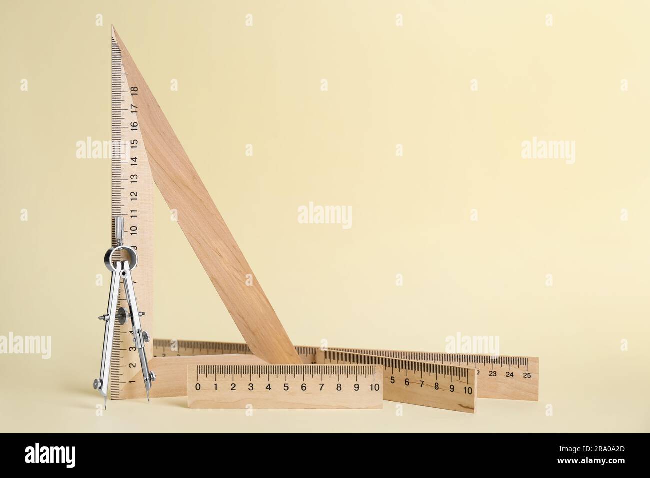 Different rulers and compass on light yellow background Stock Photo - Alamy
