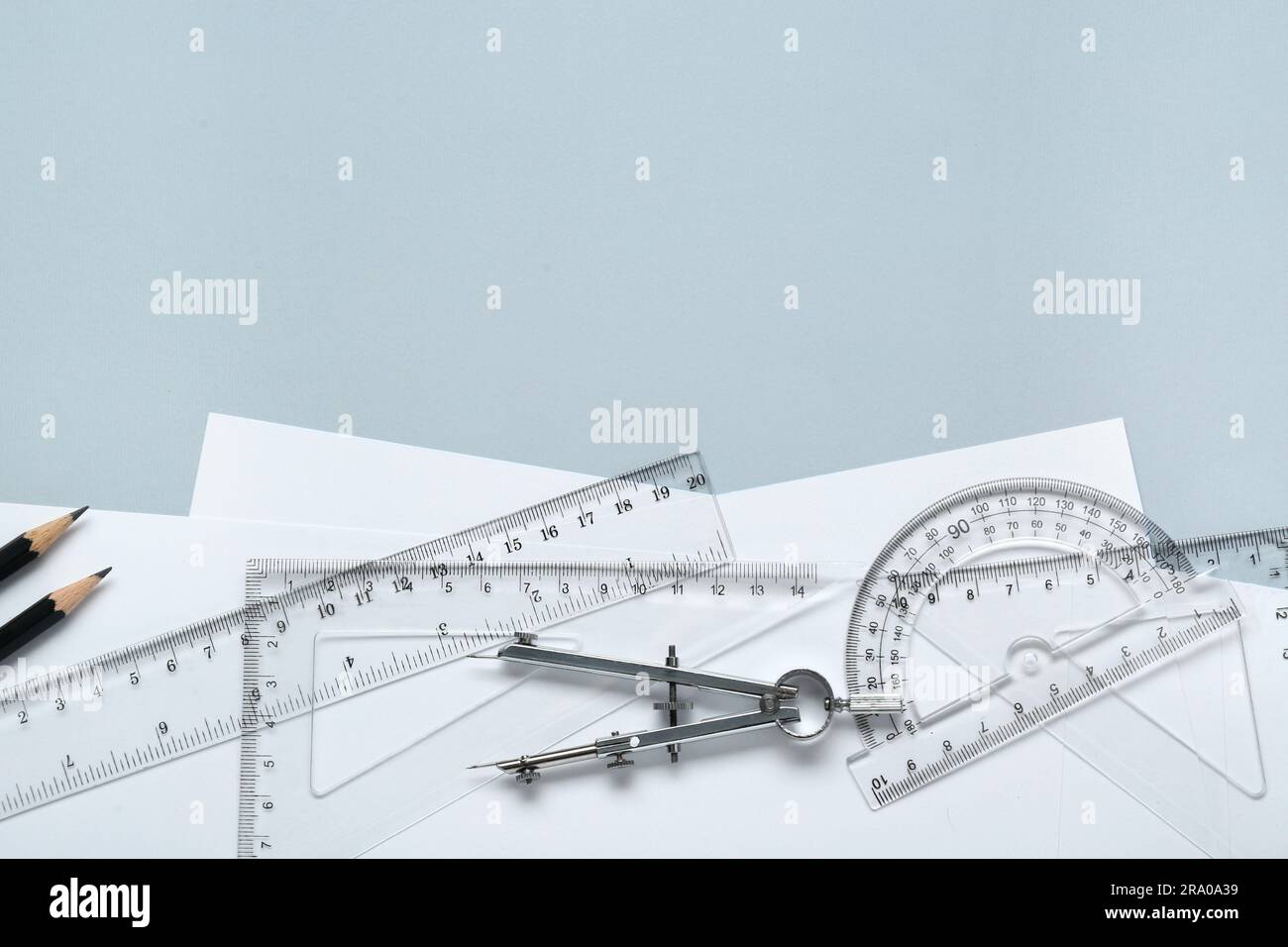 Flat lay composition with different rulers and compass on light grey ...