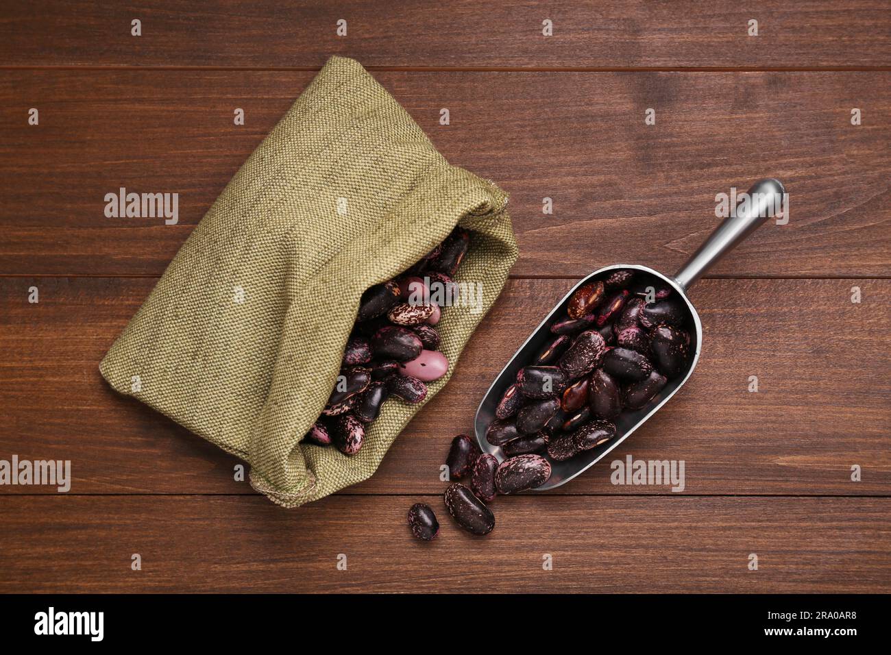 Metal scoop and sack with dry kidney beans on wooden table, flat lay ...