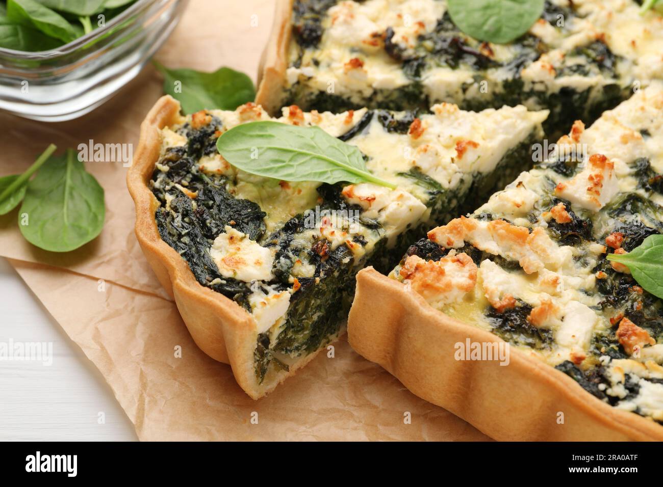 Delicious homemade spinach quiche on parchment paper, closeup Stock ...