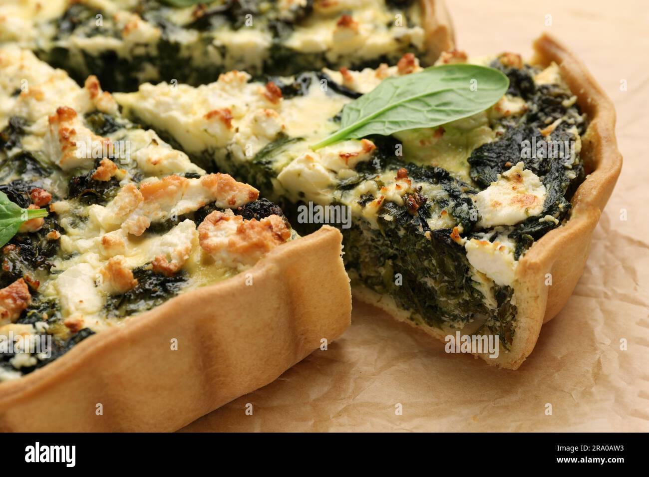 Delicious homemade spinach quiche on parchment paper, closeup Stock ...