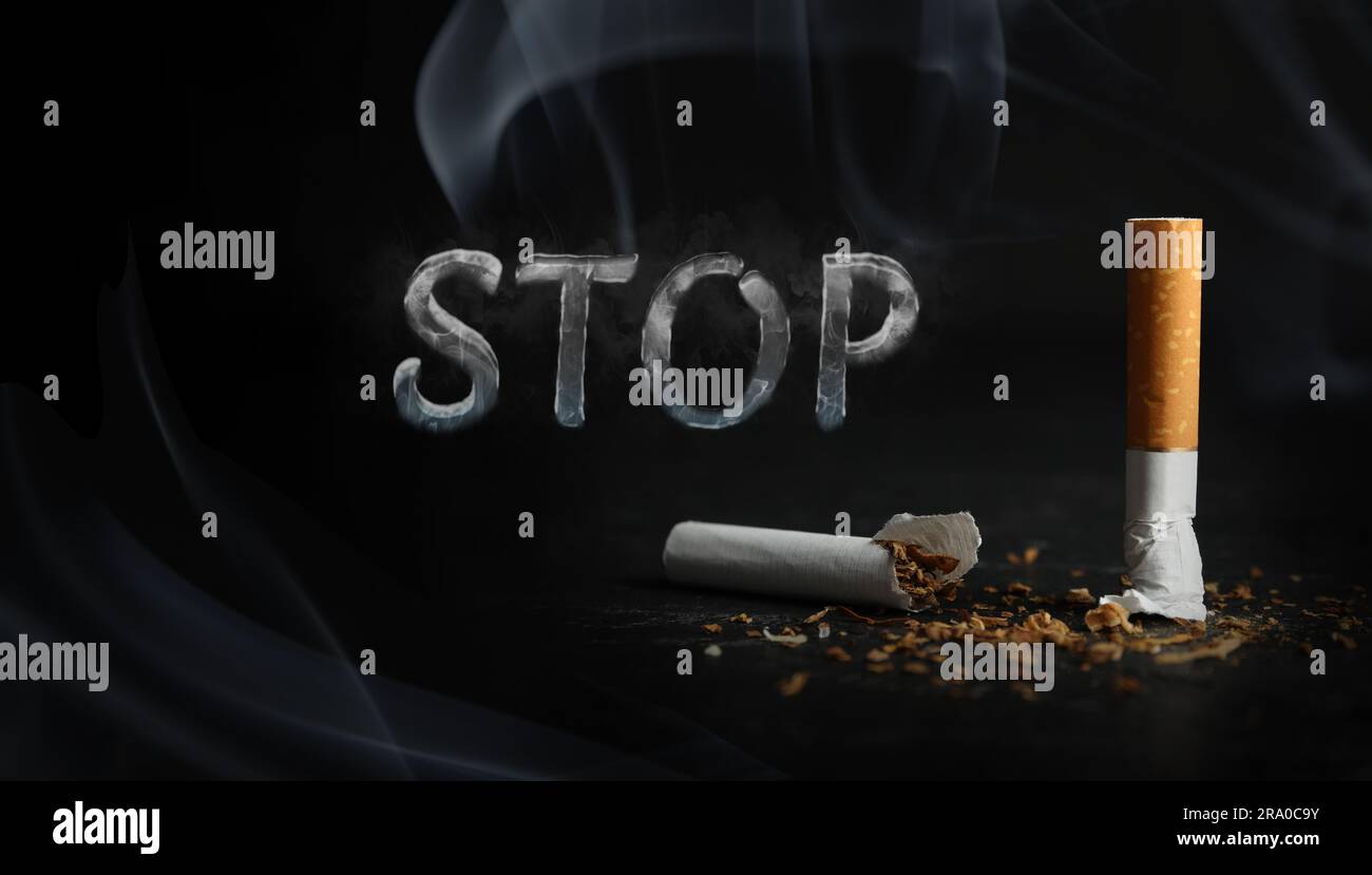 Quit smoking. Word Stop of smoke and broken cigarette on black ...