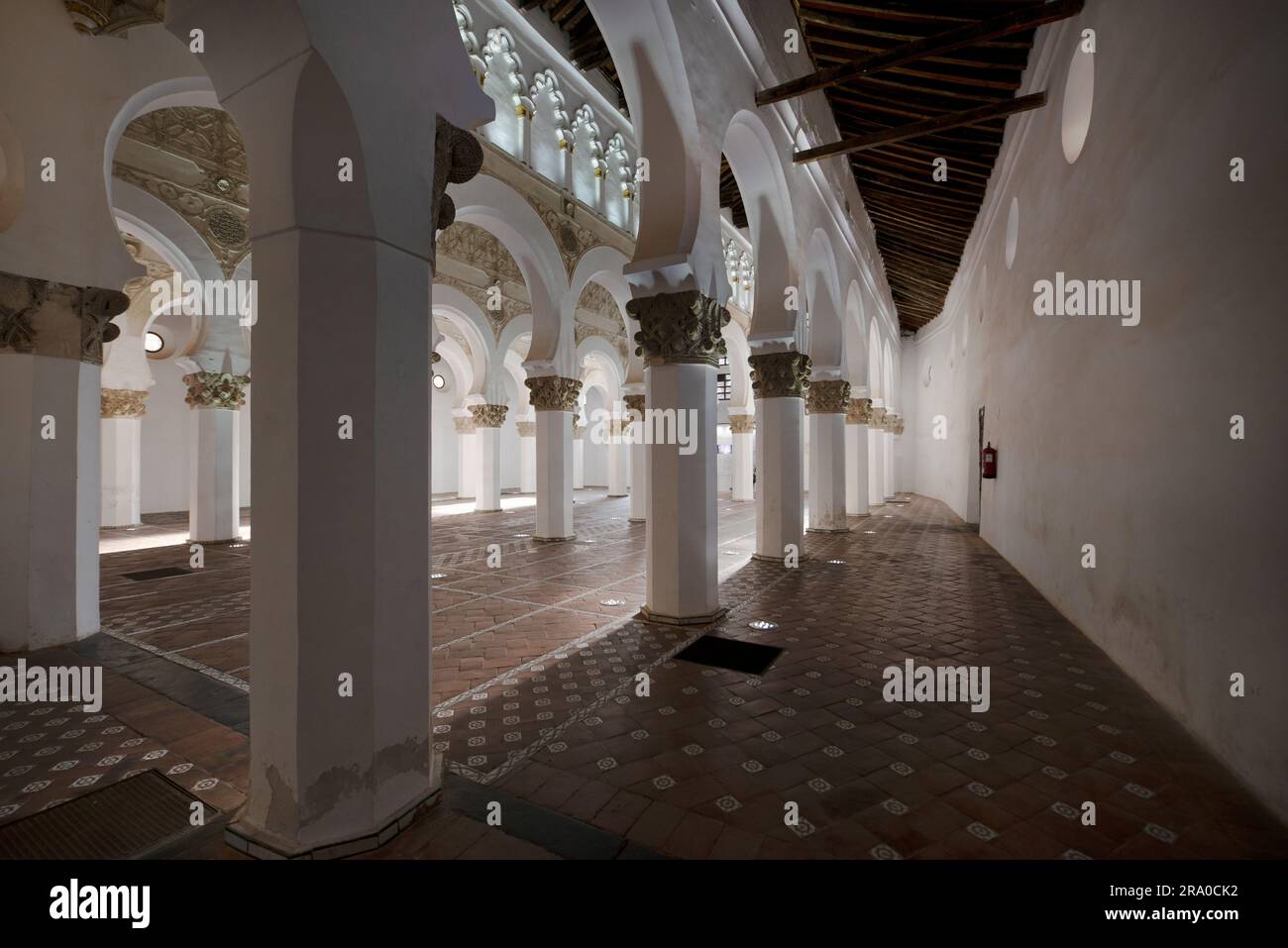 Main nave of the Toledo synagogue with whitewashed walls and old wooden ...
