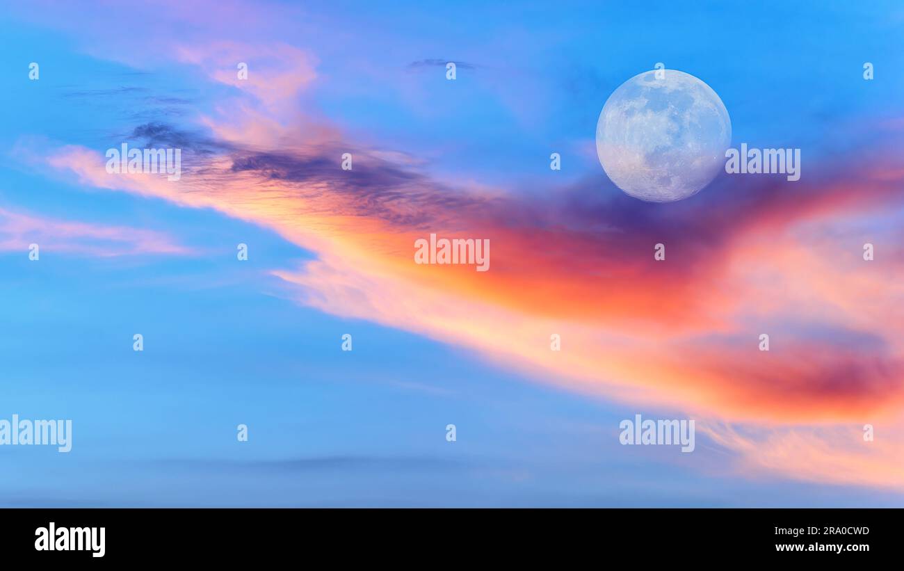 A Full Moon Is Rising In A Colorful Sunset Blue Daytime Sky Stock Photo ...