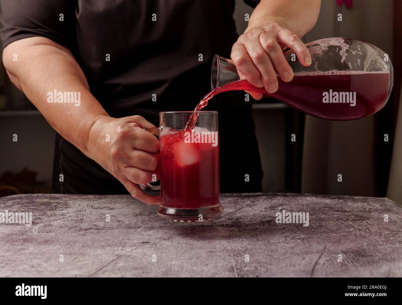Waitress dressed in black serving a pitcher of sparkling summer red ...