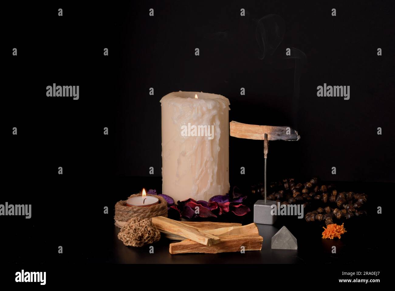 Palo santo (holy stick) with lighted candles and japa mala on black ...