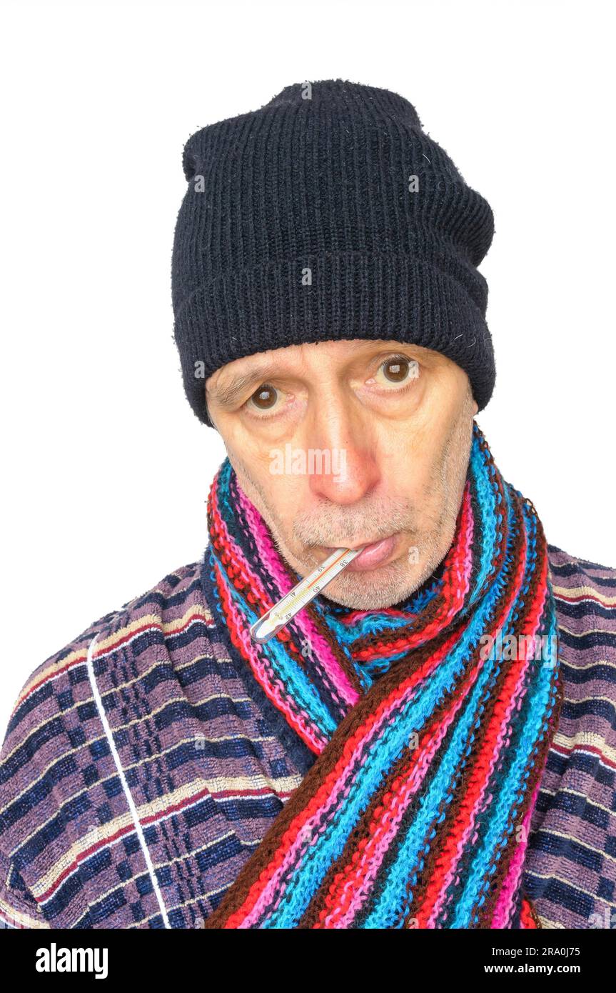 Sick man with the flu and temperature, wearing a cap and a woolen scarf ...