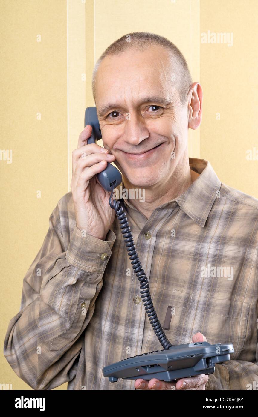 Happy smiling man speaking on phone at home Stock Photo - Alamy