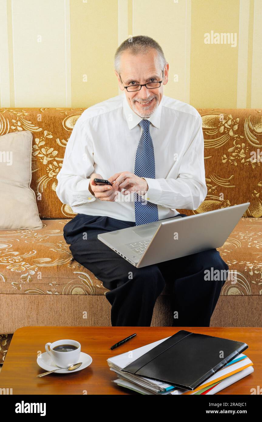 An handsome senior businessman working with computer at home, typing a ...