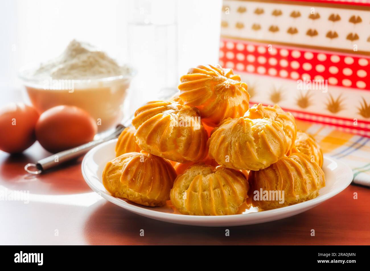 Puffs in a plate. Eggs, flour and whip in close to the window in ...