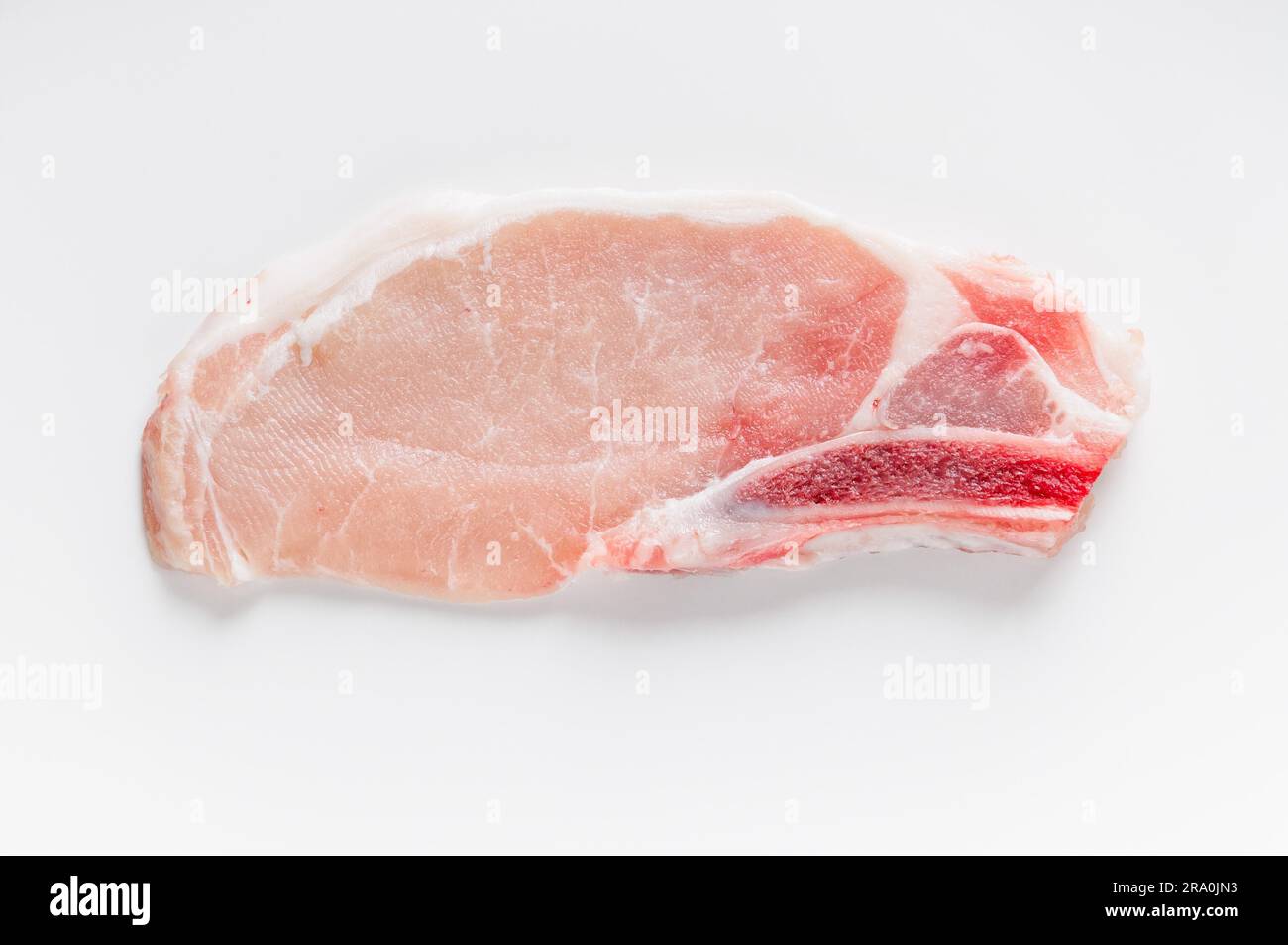 A chop of raw pork on a white background Stock Photo - Alamy