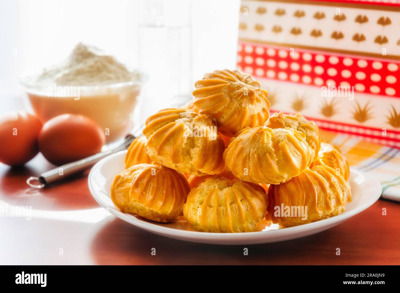 Puffs in a plate. Eggs, flour and whip in close to the window in ...