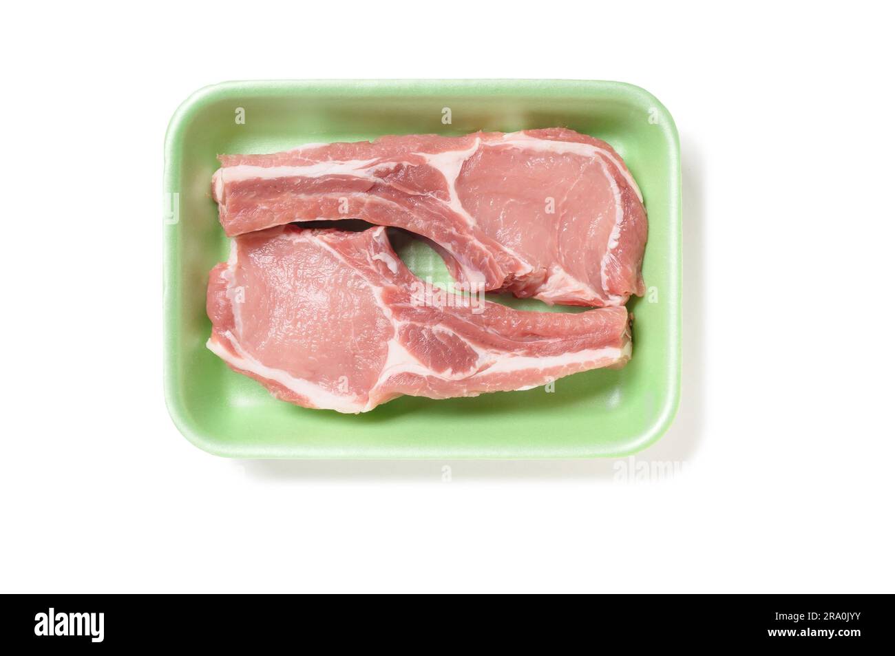 Two pork ribs with fillet in a green foam tray, isolated on white ...