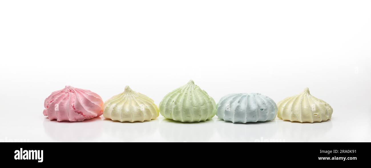 Five colored french meringues aligned in a row, on white background ...