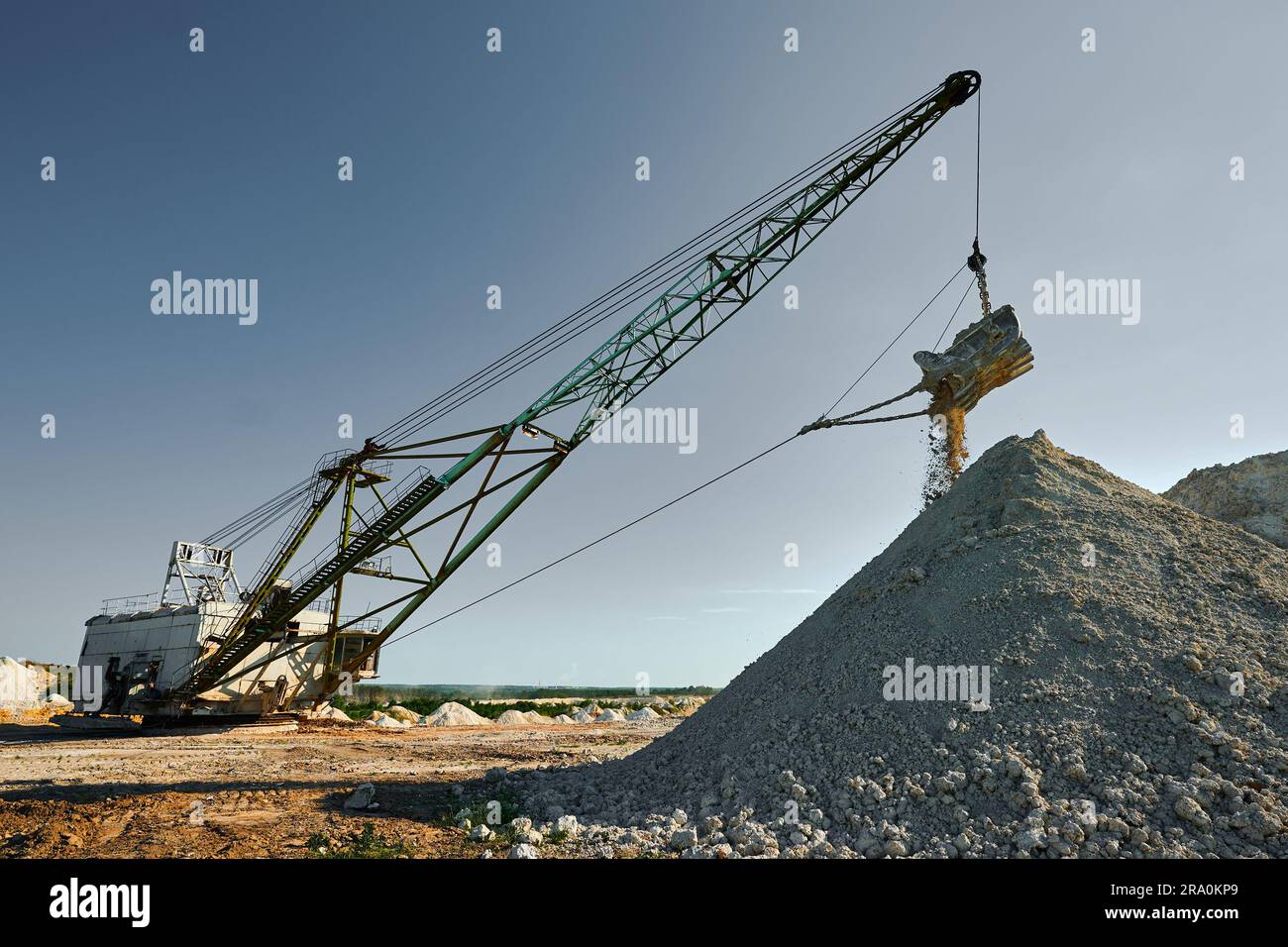 Dragline pours chalk from bucket operating in open quarry Stock Photo ...