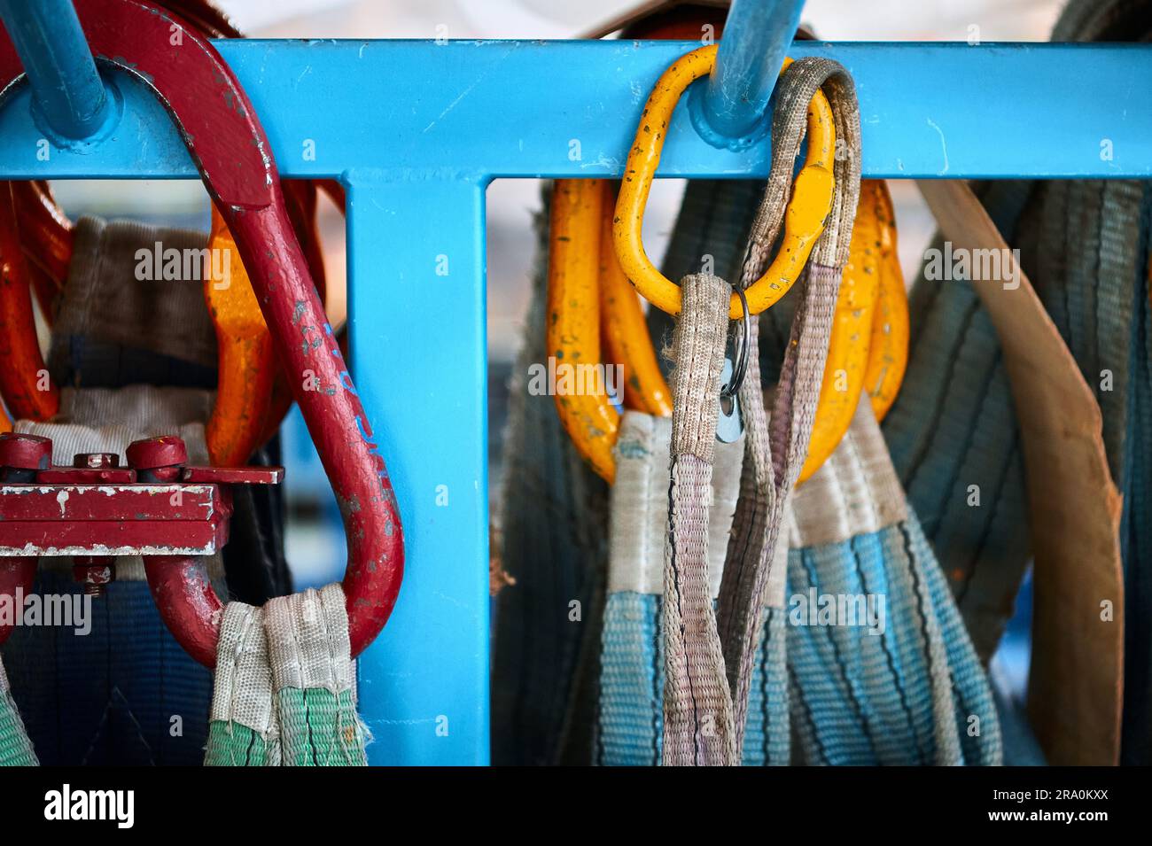 Rigging equipment with strops hangs on rack in warehouse Stock Photo ...