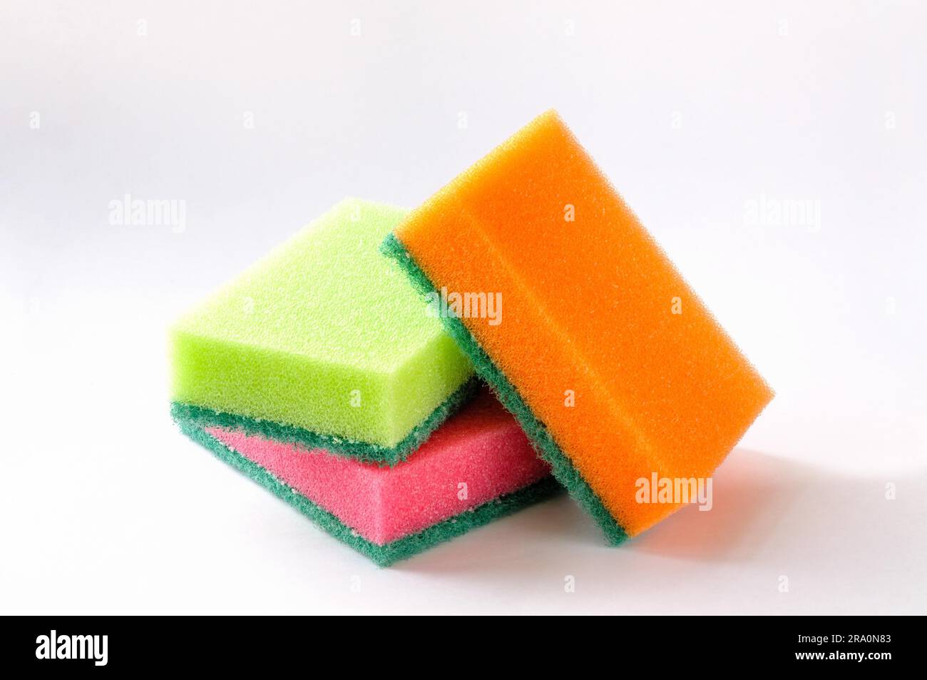 Three colored sponges on a white background Stock Photo - Alamy