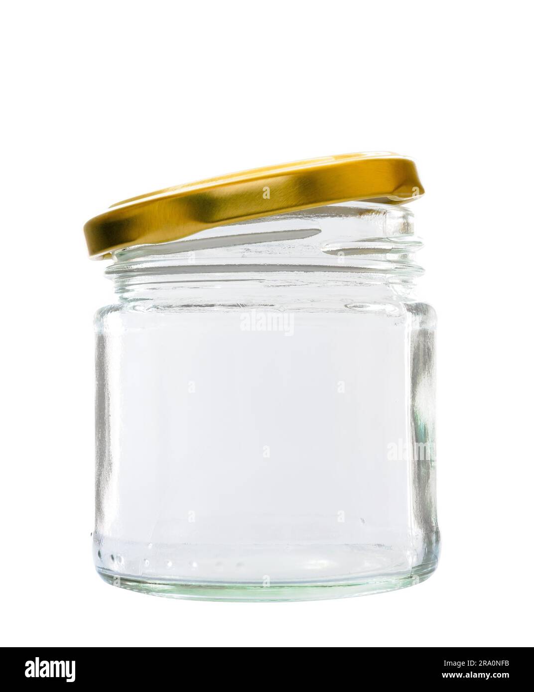 Transparent glass jar on white background, with the open gold color top ...