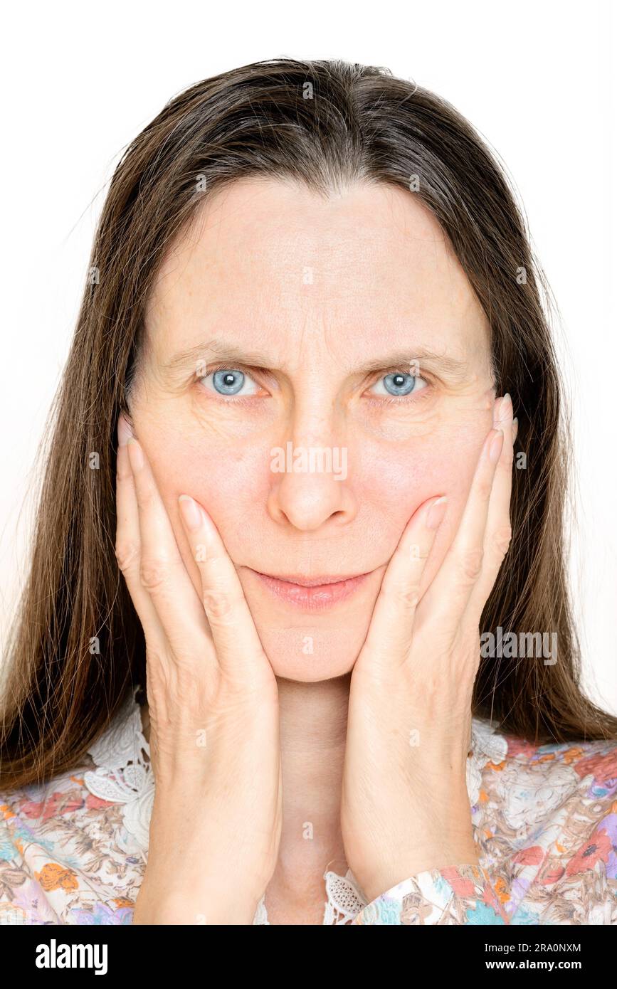 An angry senior woman portrait, with the hands on the face Stock Photo ...