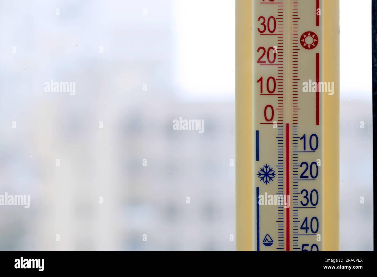 A thermometer, fixed out of the window, shows that it is zero degree ...