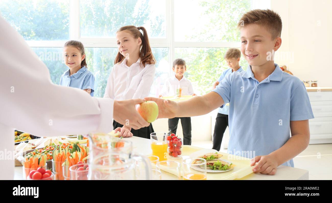 Group of pupils receiving lunch in school canteen Stock Photo - Alamy