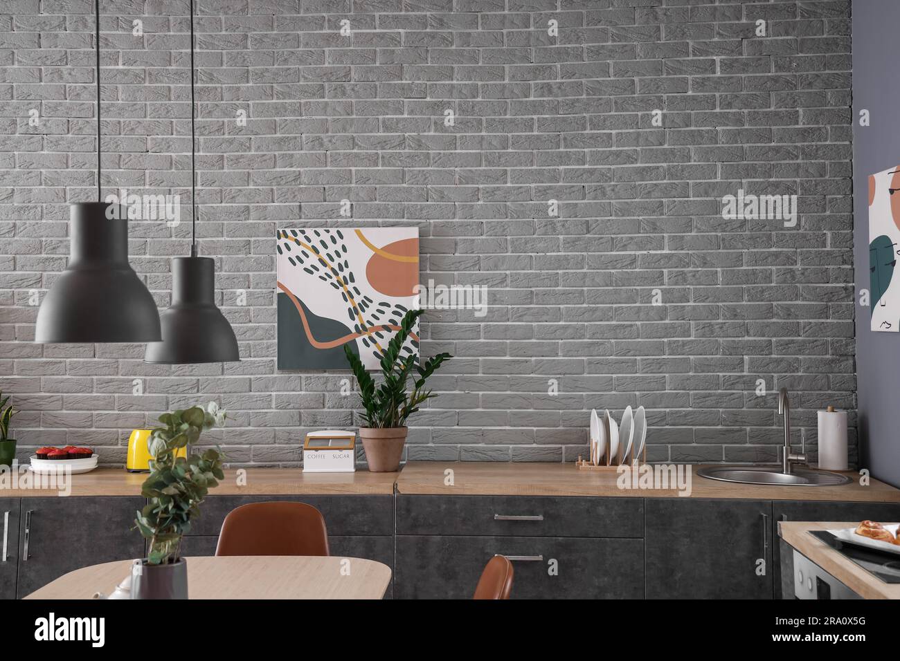 Interior of modern kitchen with dining table and grey counters Stock ...