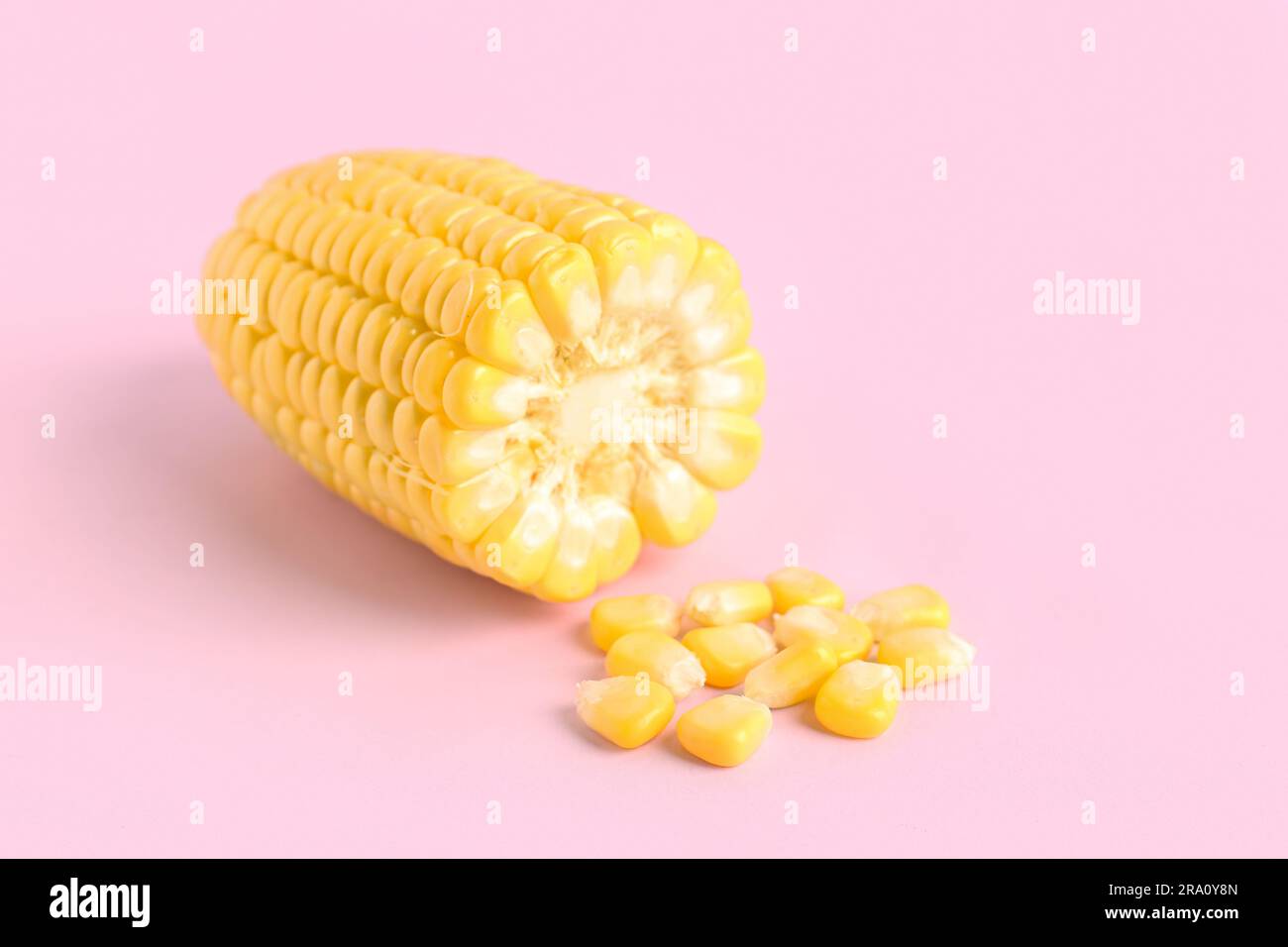Cut fresh corn cob and seeds on pink background Stock Photo - Alamy