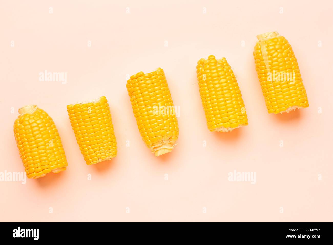 Cut fresh corn cobs on pink background Stock Photo - Alamy