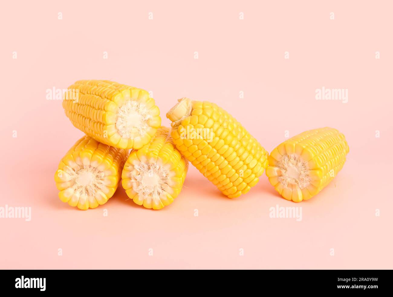 Cut fresh corn cobs on pink background Stock Photo - Alamy
