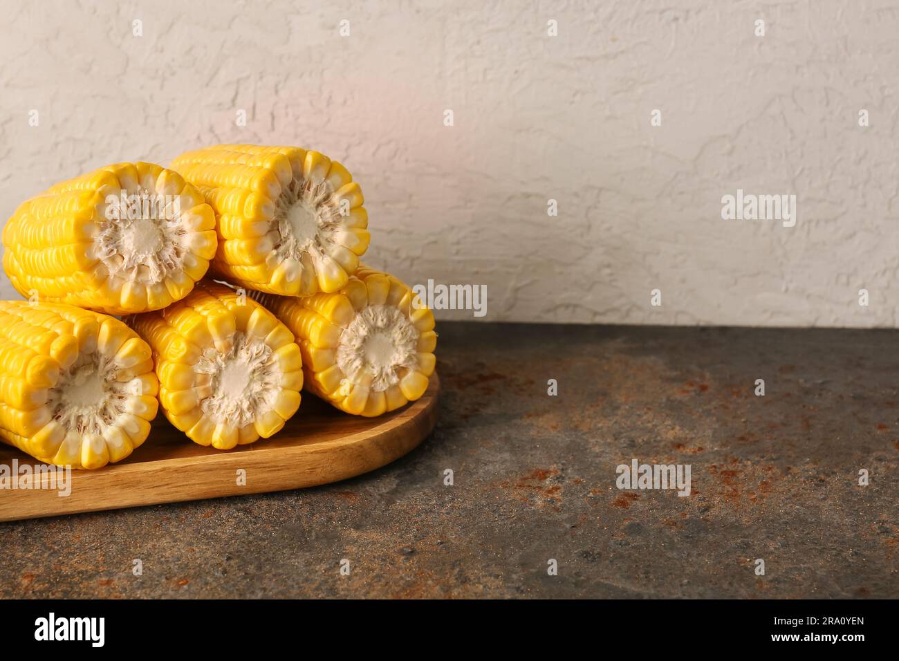 Wooden board with cut fresh corn cobs on dark table Stock Photo - Alamy