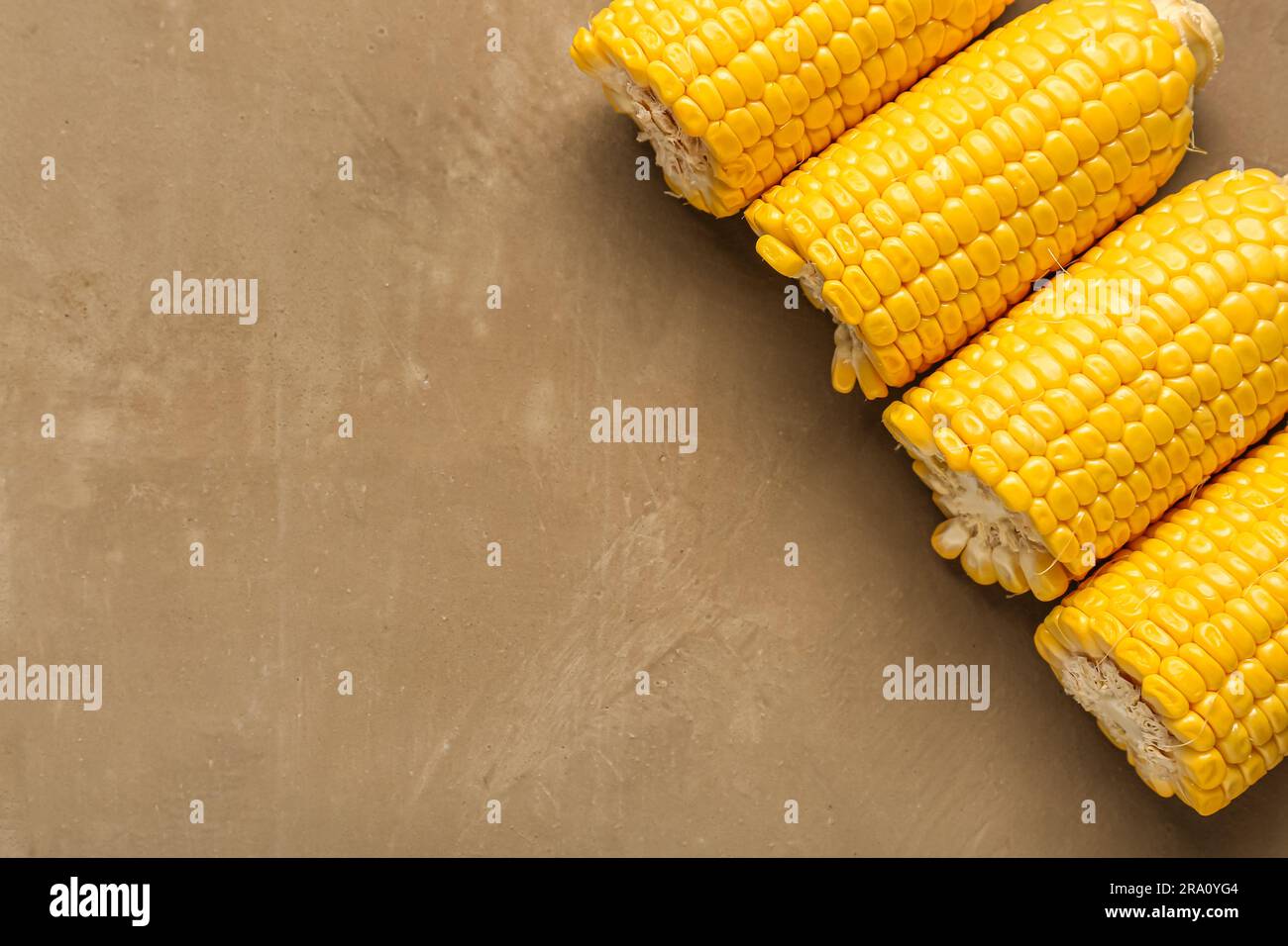 Cut fresh corn cobs on brown background Stock Photo - Alamy